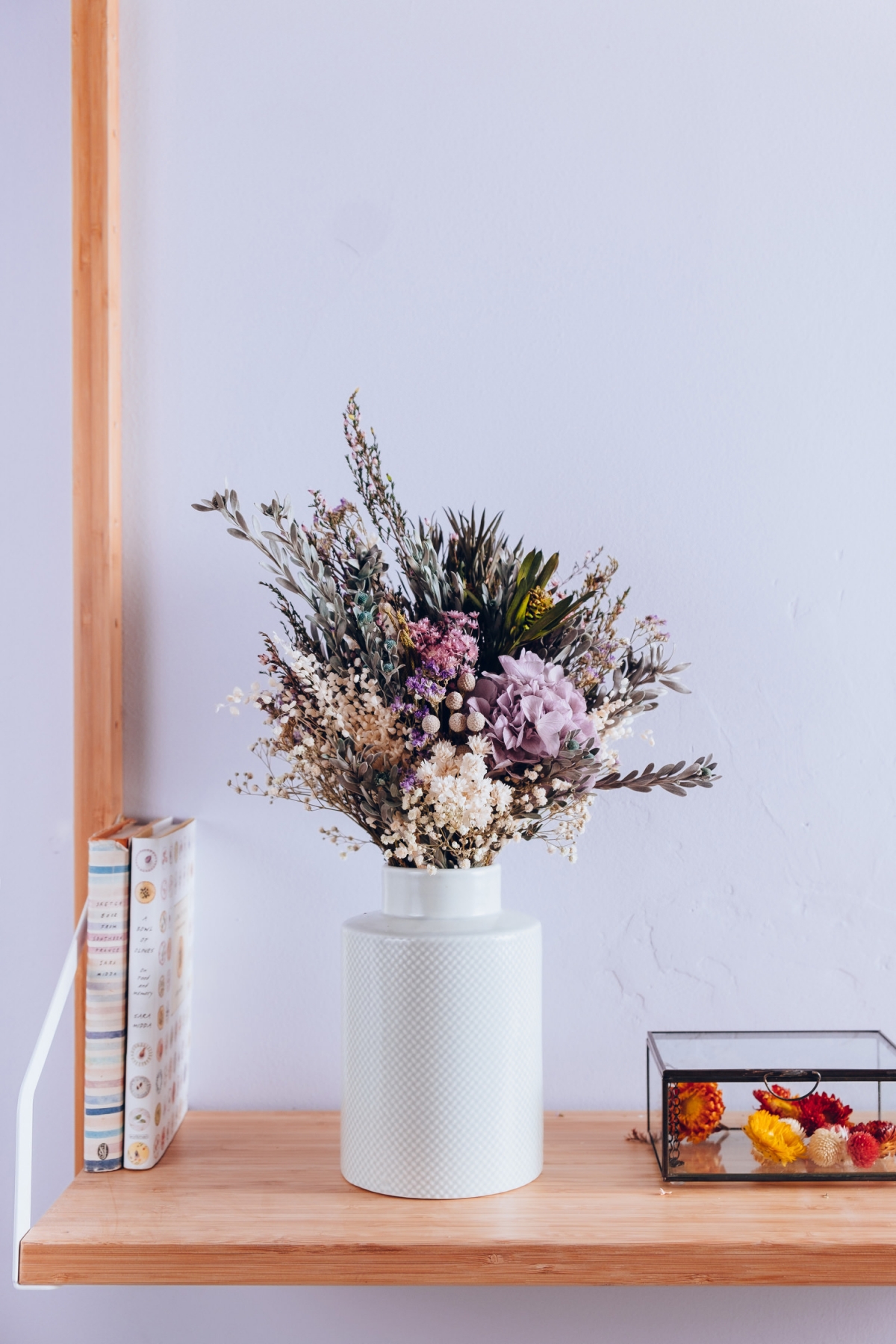 Jarrón de cerámica blanco con flores preservadas silvestres